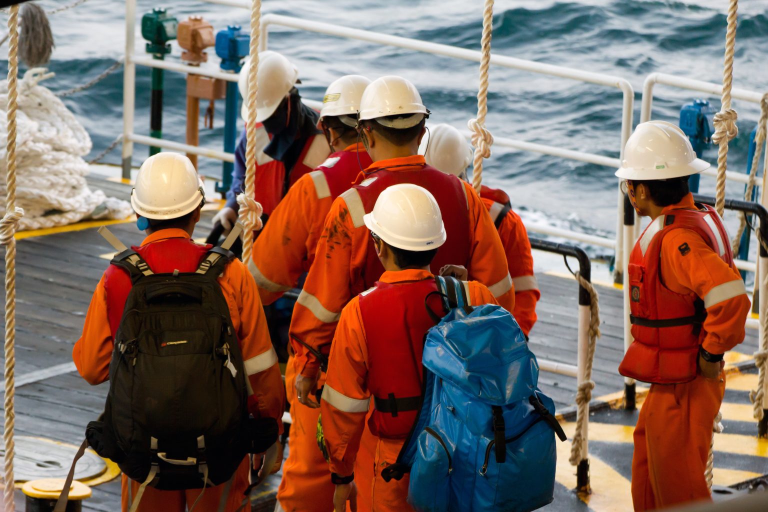 Rig workers using a swing rope prior of being transported to nearby ...